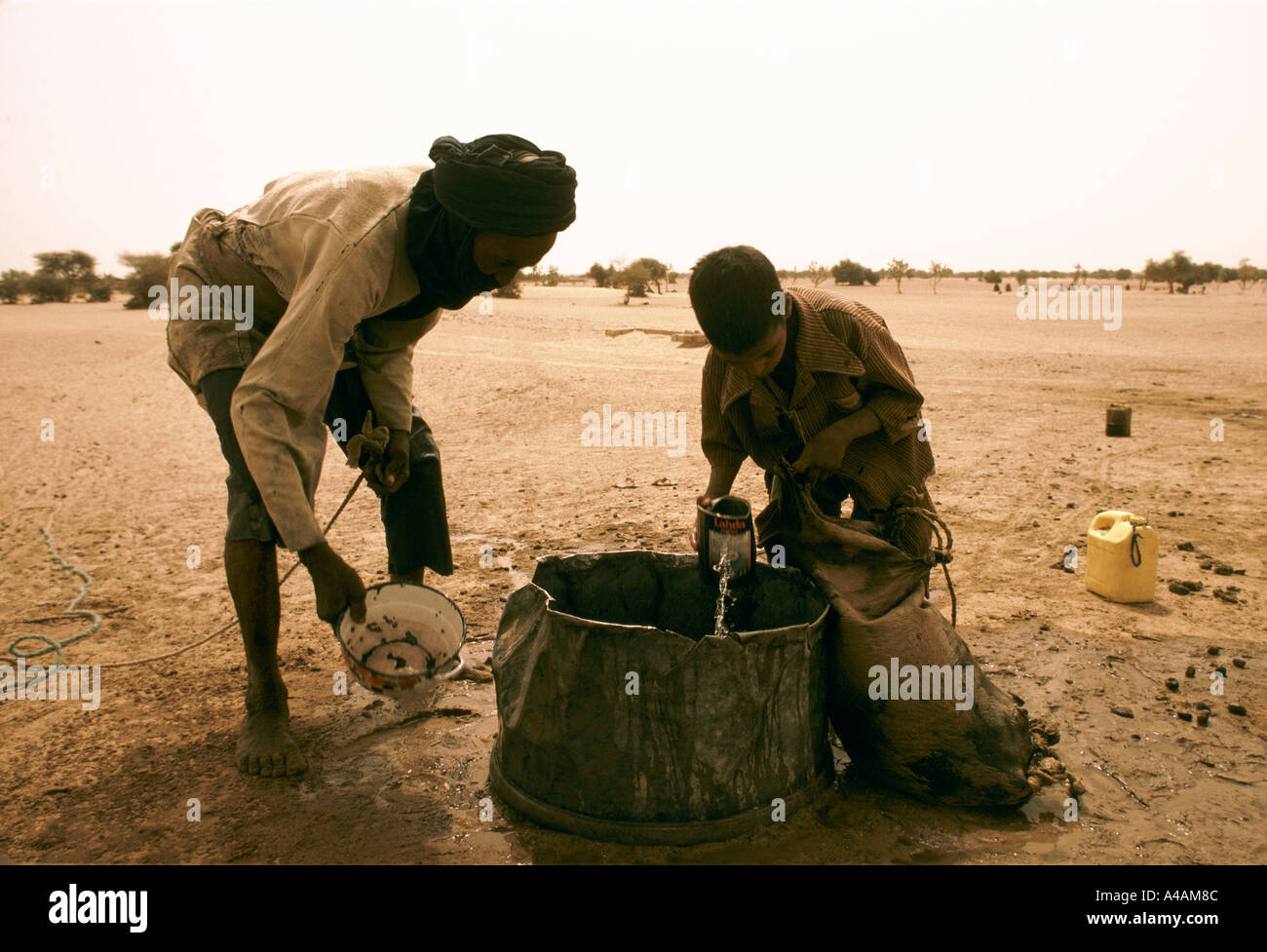 pumping during well construction mali man boy filling bag for carrying ...