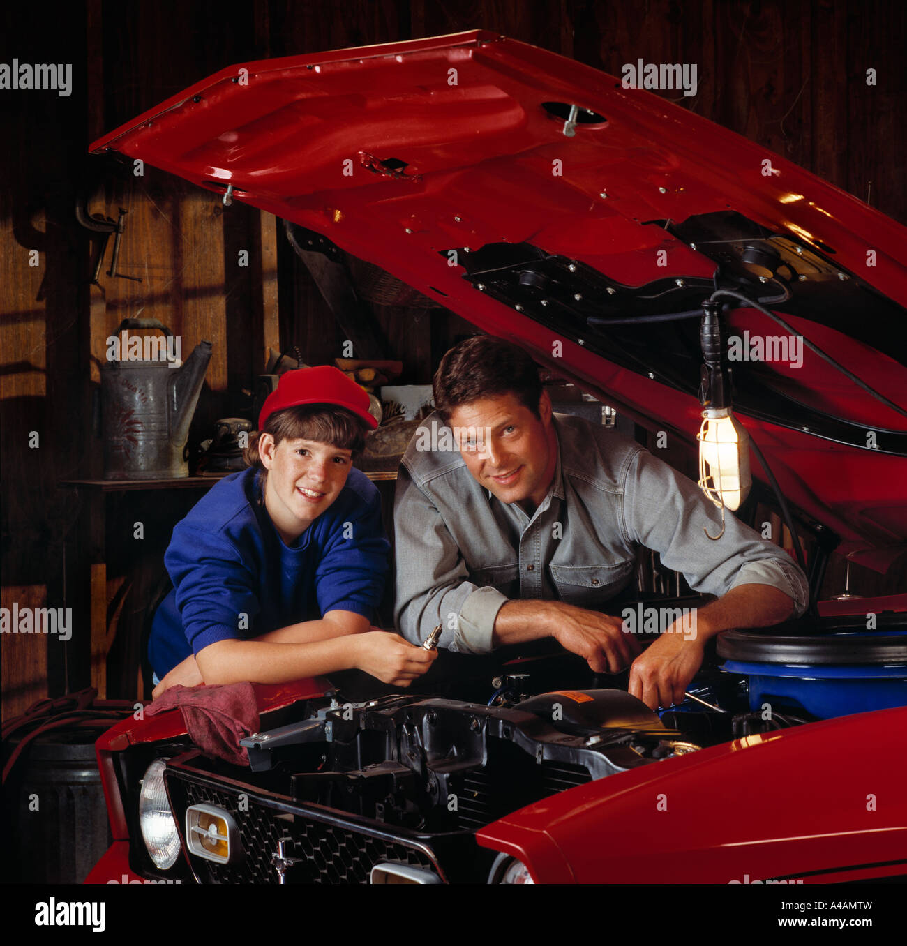 Father and daughter work on a classic car in a garage Stock Photo - Alamy