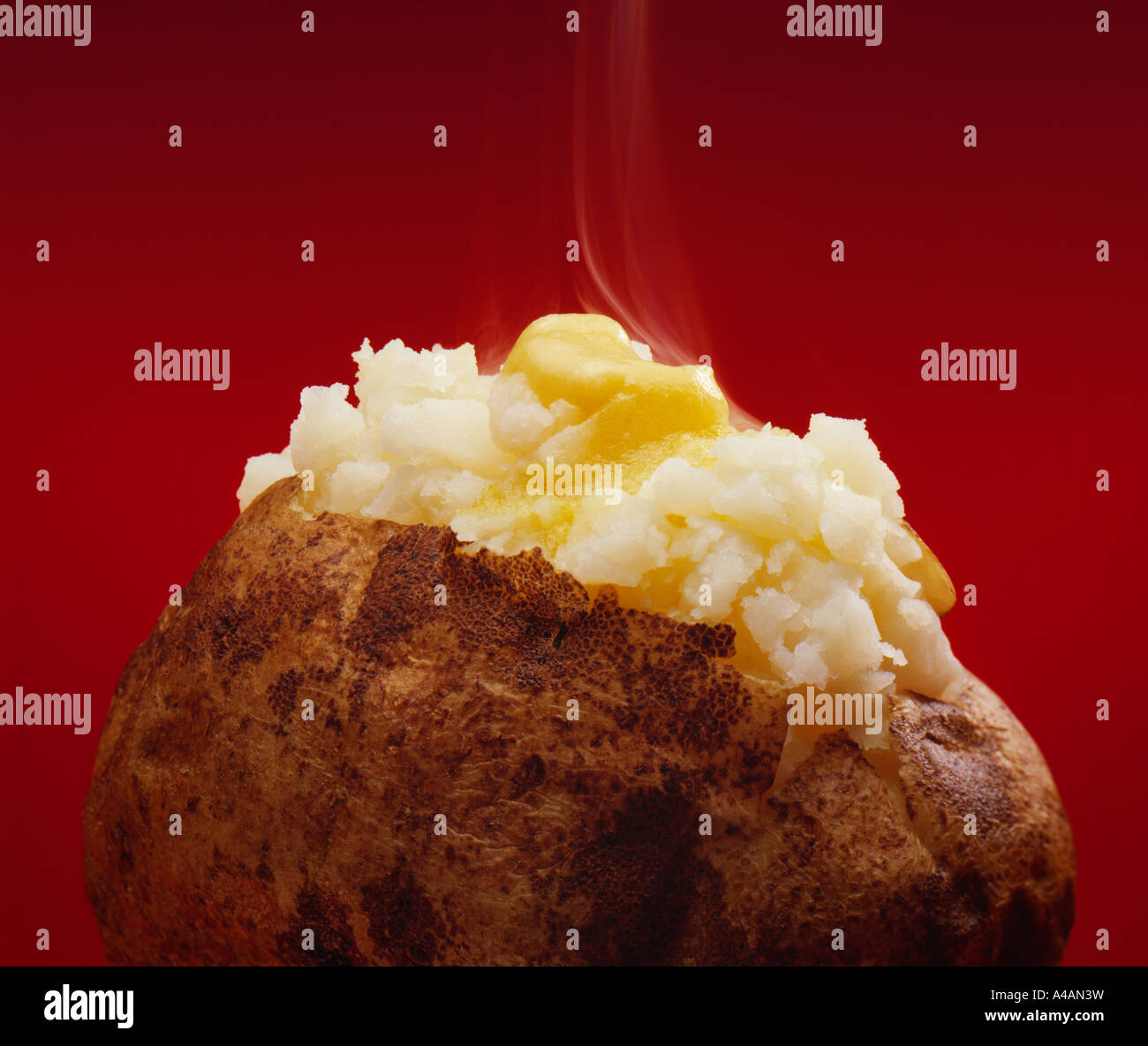 A hot baked potato with butter lets off steam Stock Photo - Alamy