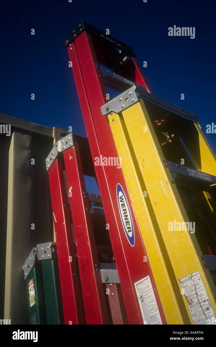 Several colorful ladders stacked against shed Stock Photo - Alamy