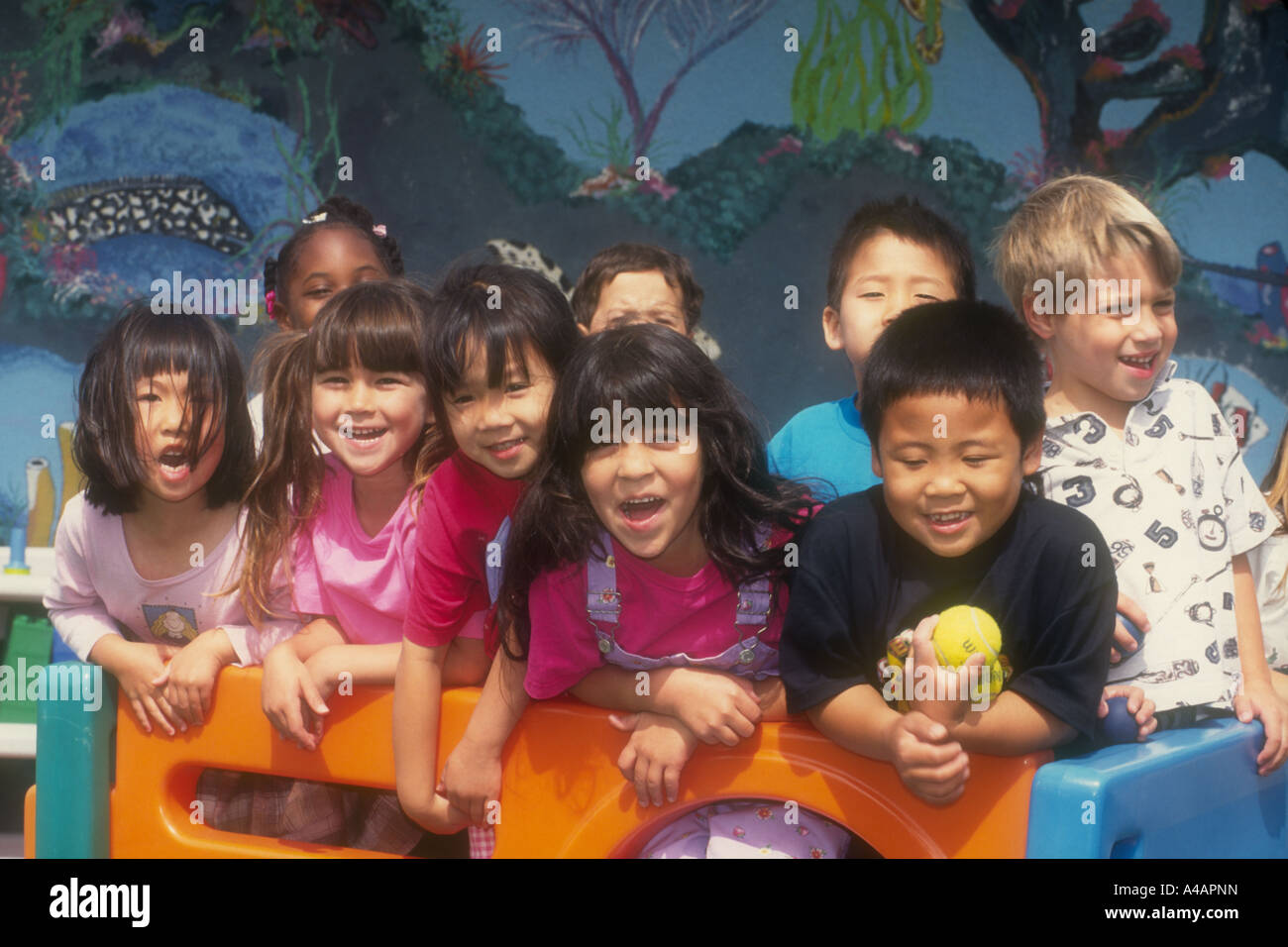 Multicultural group of preschoolers having fun together at play time ...