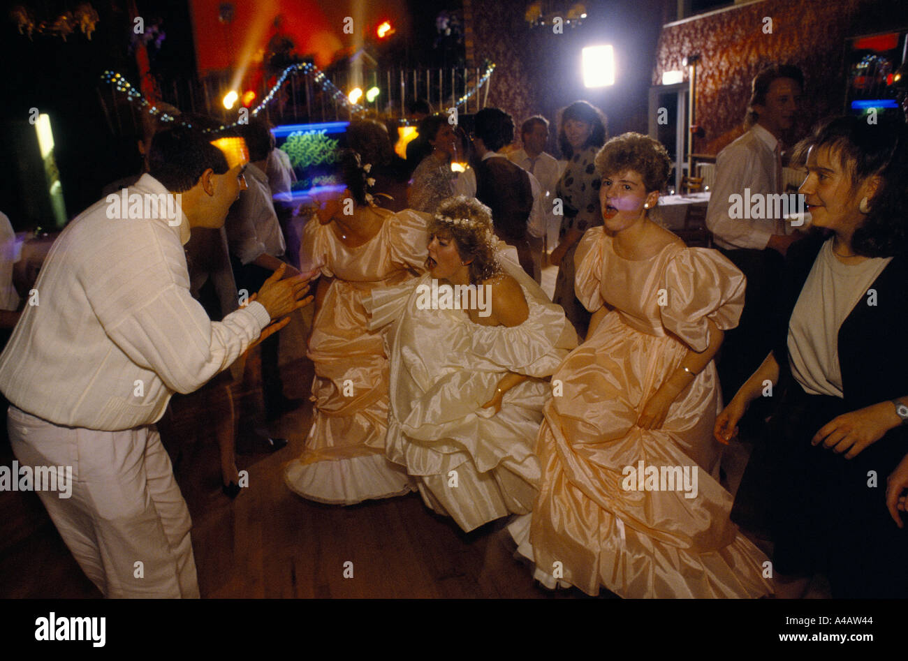 bride bridesmaids and other guests dance at wedding reception a male ...