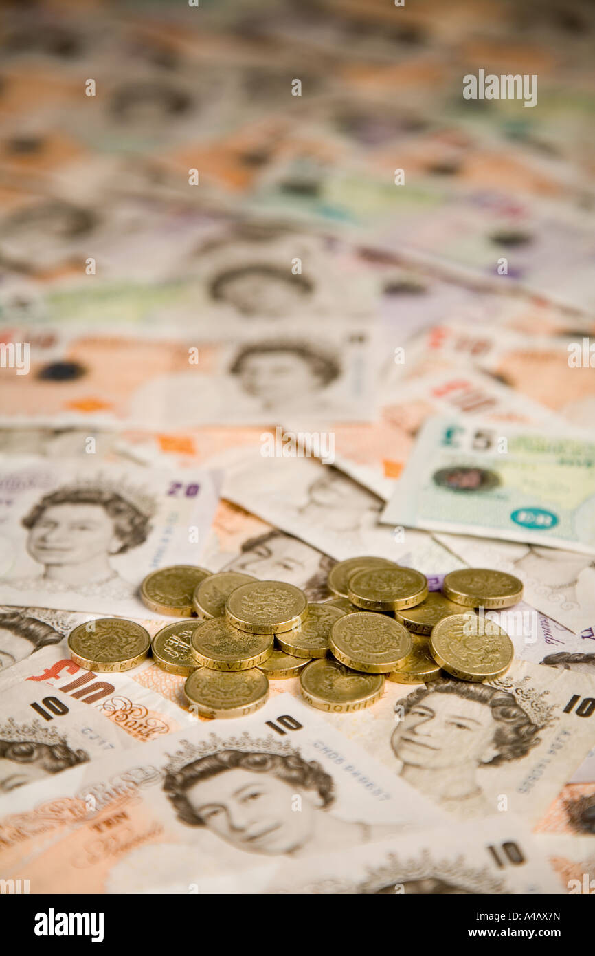 A pile of 1 pound coins on an assortment of used 5 10 and 20 pound ...