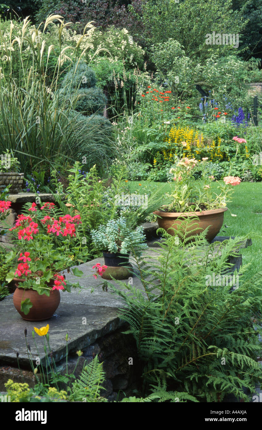 stone bench with plants in containers Stock Photo - Alamy