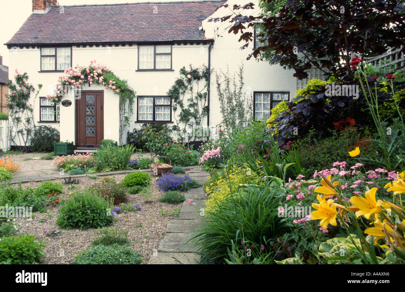mediterranean garden with gravel area and roses around the cottage door ...