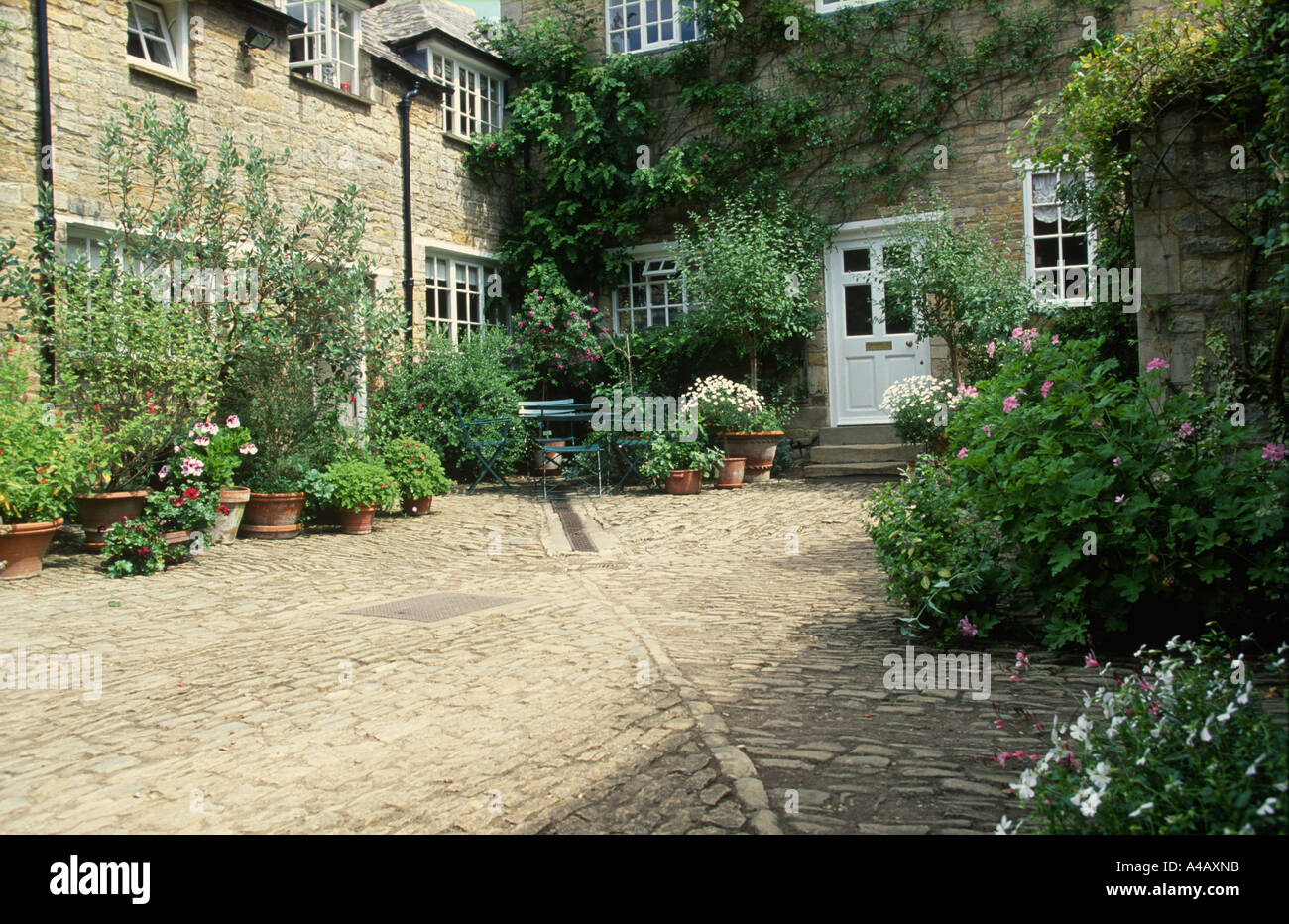 large courtyard garden with cobbles and containers Stock Photo - Alamy