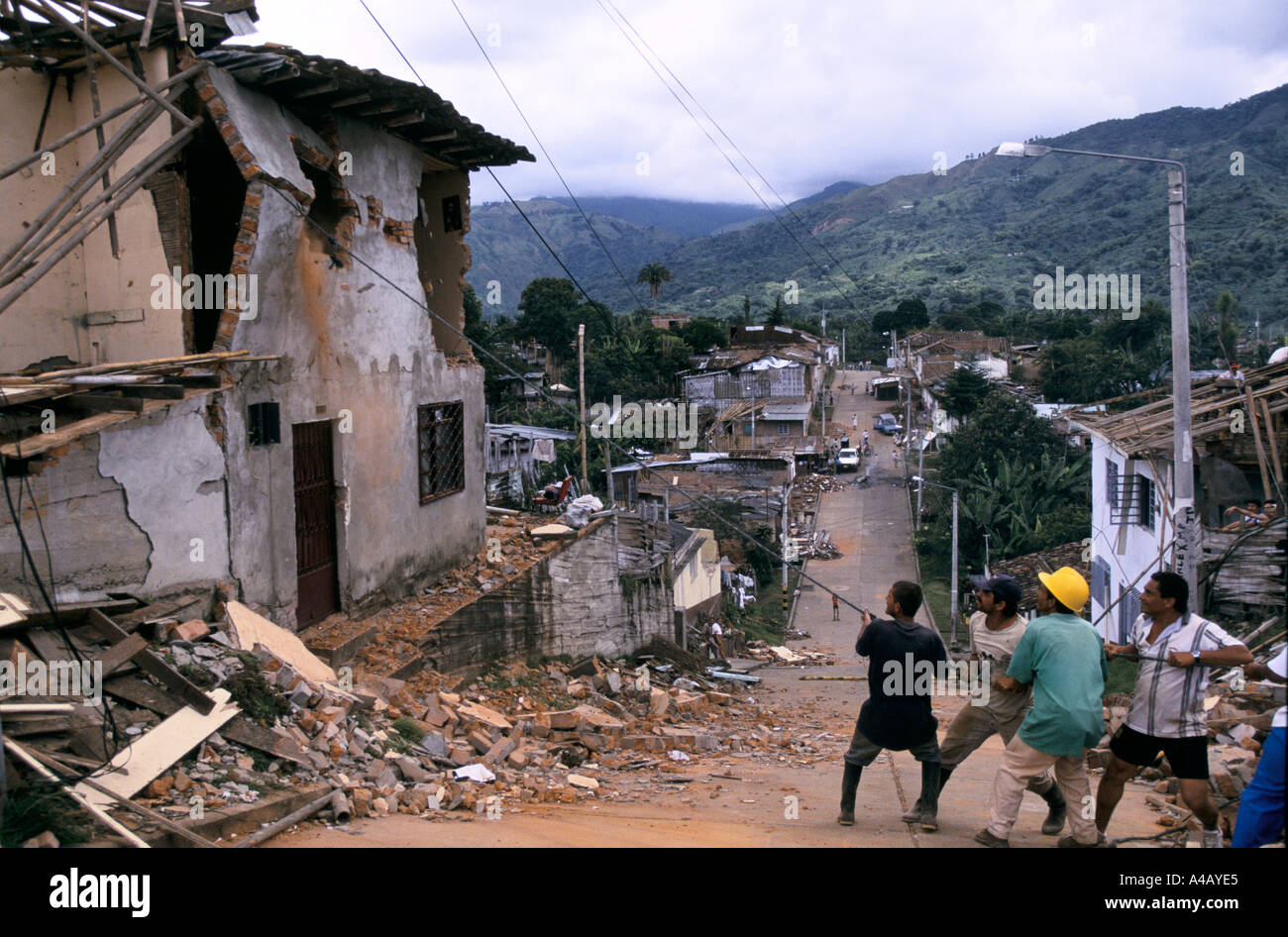 Earthquake in Colombia 1999: A man pulls down his badly damaged home ...
