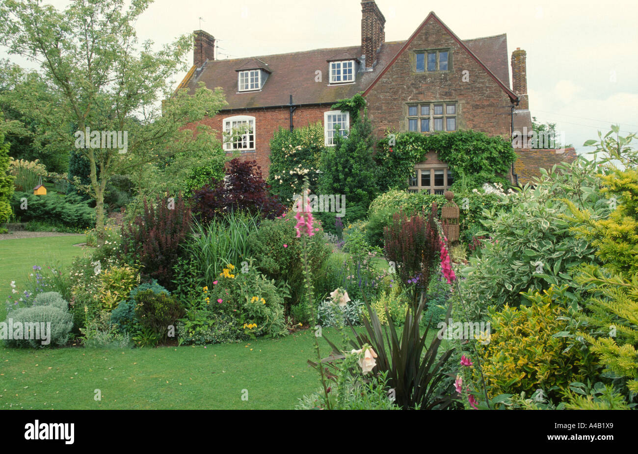 large house surrounded by well planted gardens Stock Photo - Alamy