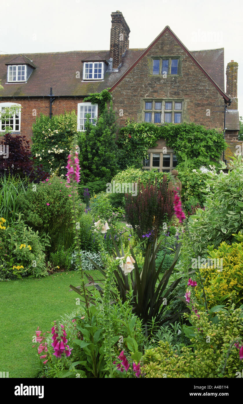 large house surrounded by well planted gardens Stock Photo - Alamy