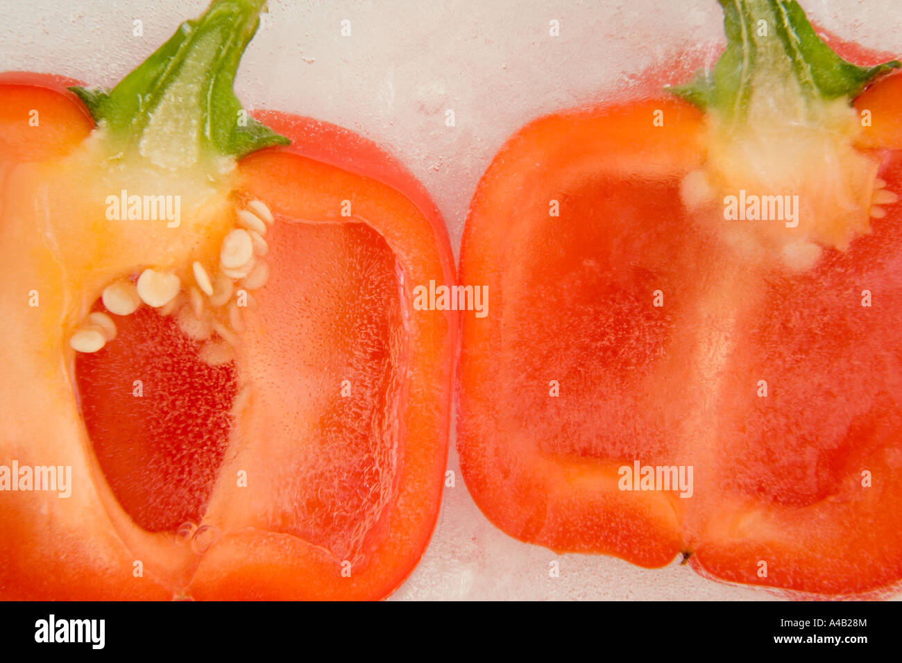 Close-up of two red pepper halves showing the inside with seeds frozen ...