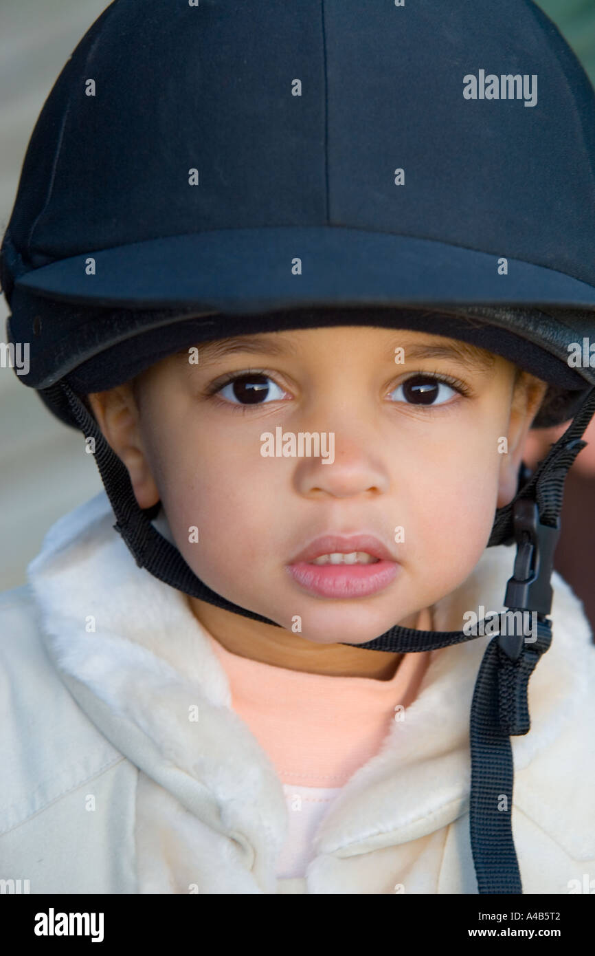 A beautiful mixed race girl wearing a riding hat Stock Photo - Alamy