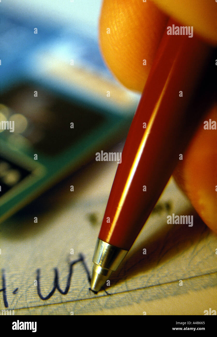 signing bank cheque check with credit debit bank card in background ...