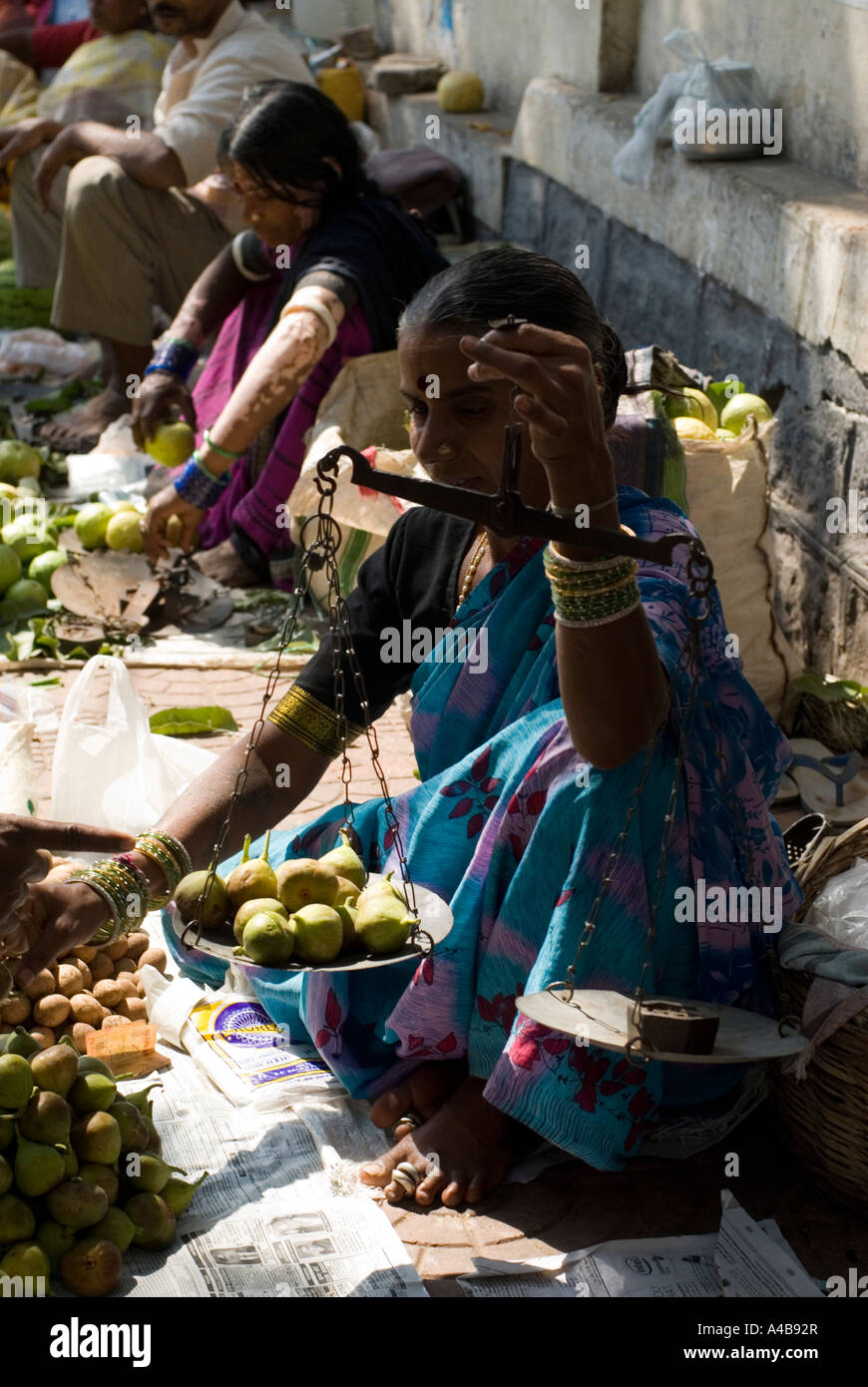Stock image of a Hindu woman in a blue sari selling fruit in Hyderabad ...