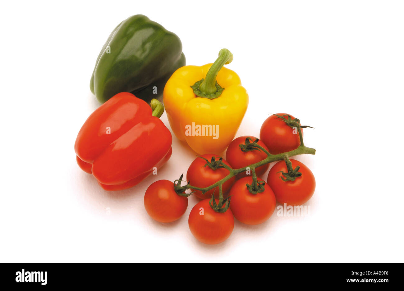 Close up of whole red yellow and green bell pepper peppers and vine ...