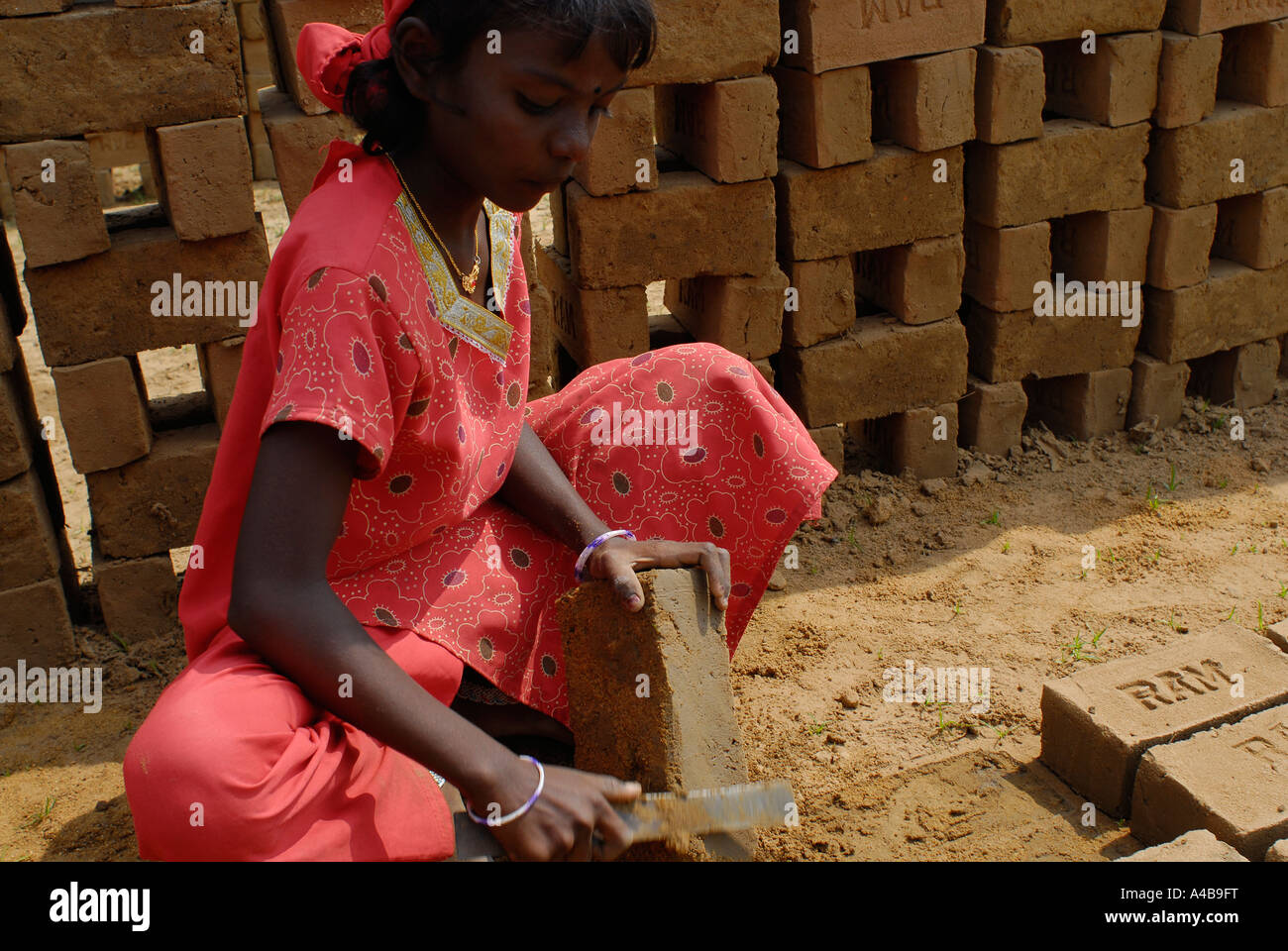 Stock image of Dalit tribal village girl working in an adobe brick ...