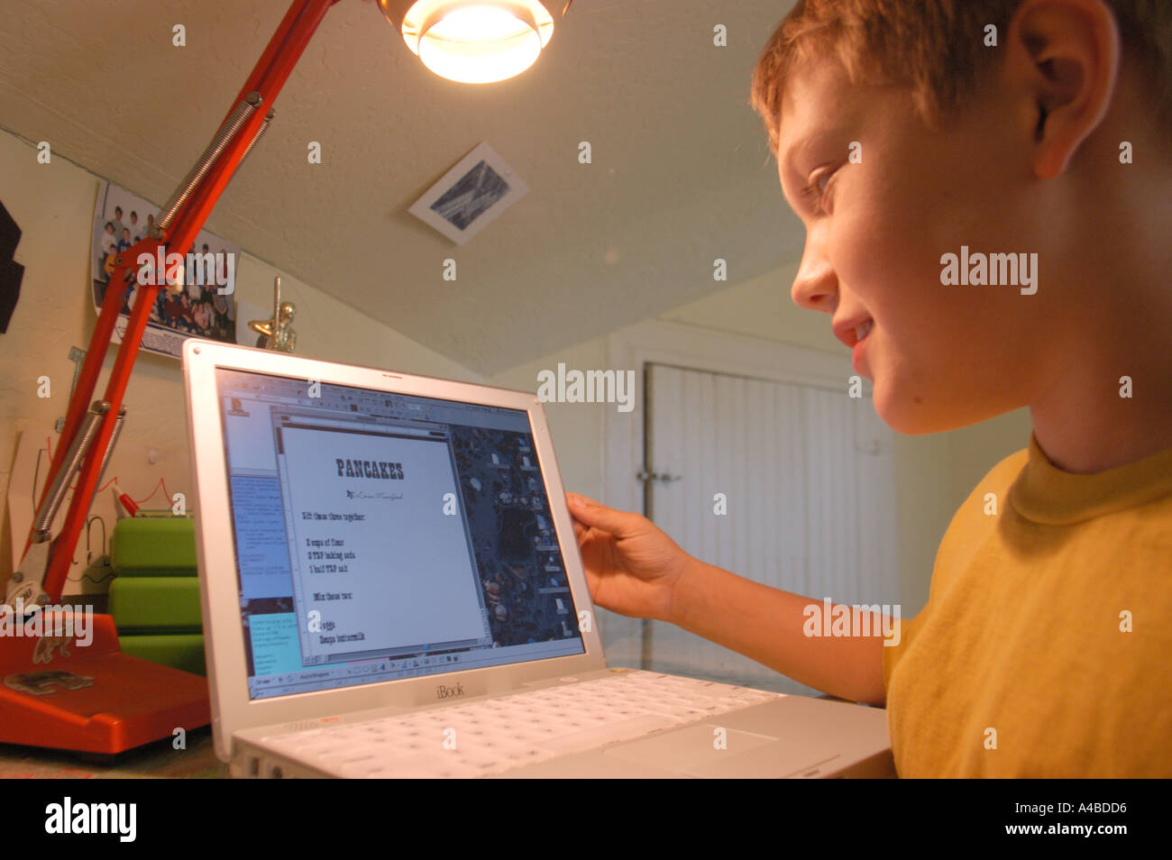 Boy working on a laptop computer at his desk at home Stock Photo - Alamy