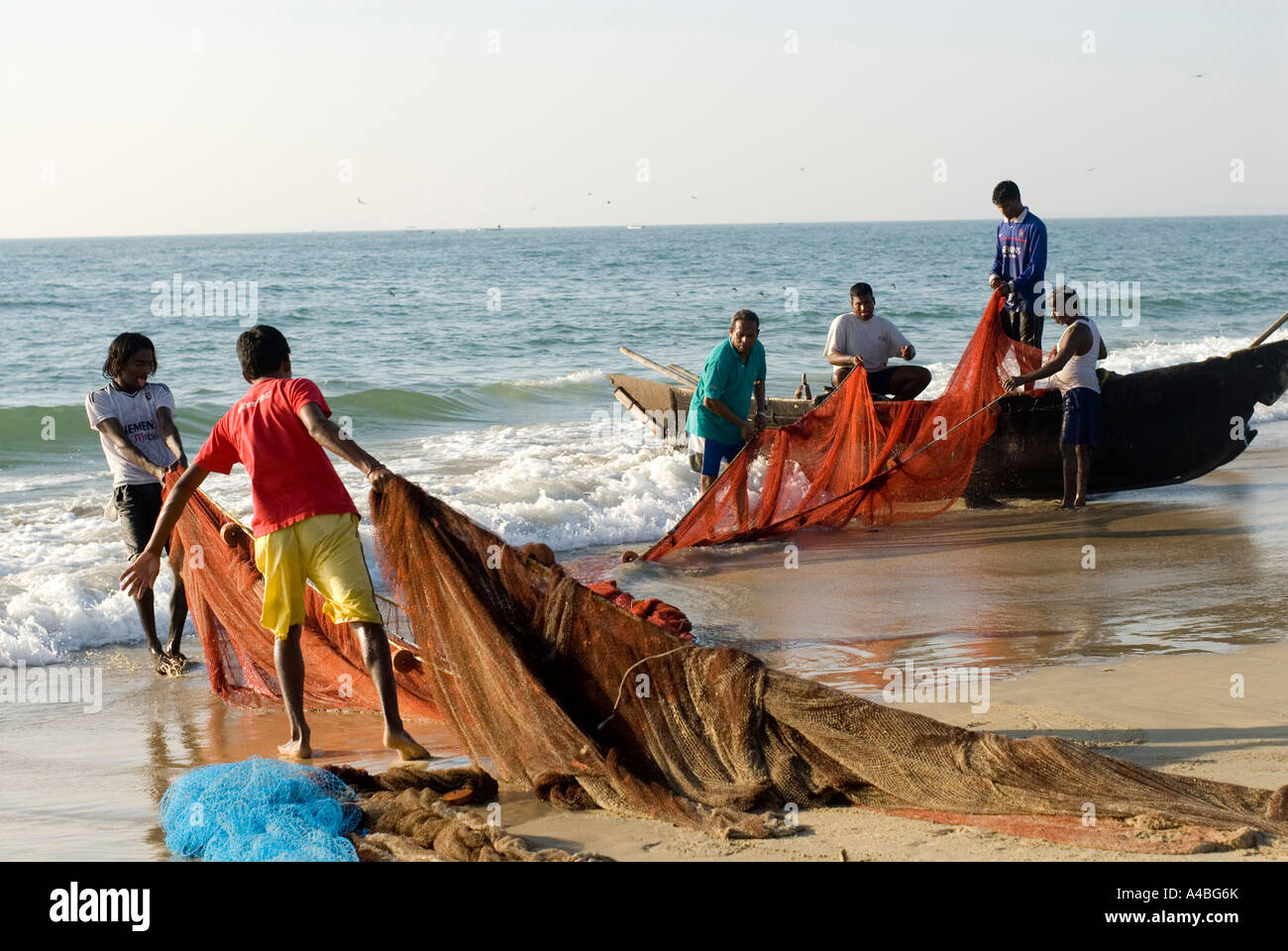 Stock image of Goan fishermen loading nets back on to their fishing ...
