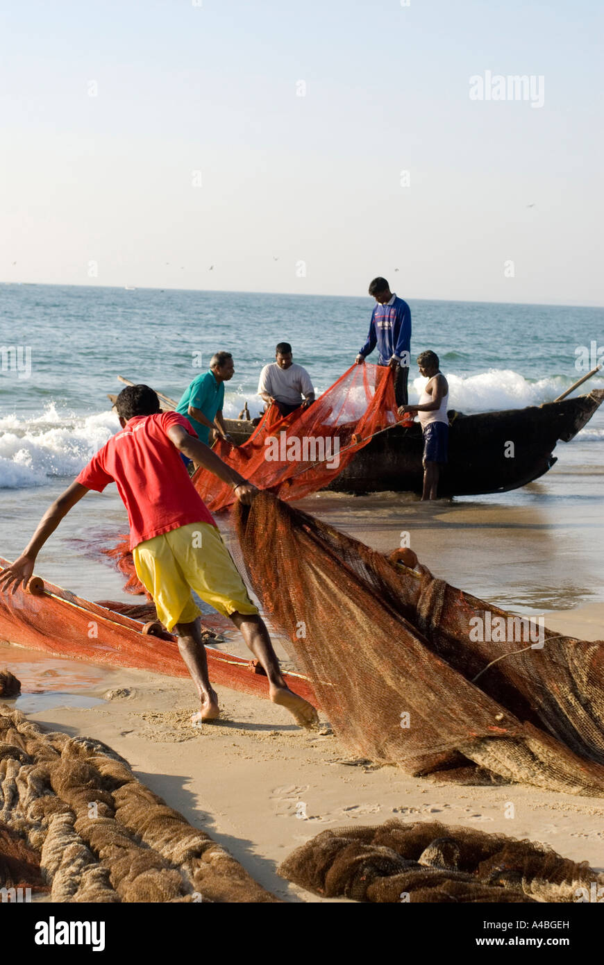 Stock image of Goan fishermen loading nets back on to their fishing ...