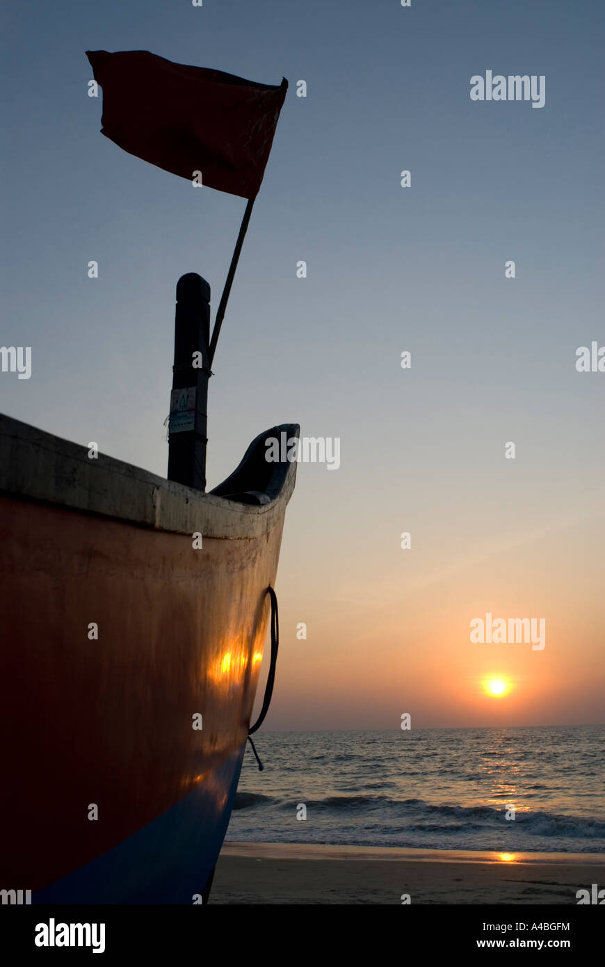 Stock image of an outrigger fishing boat in Goa with flag silhouetted ...