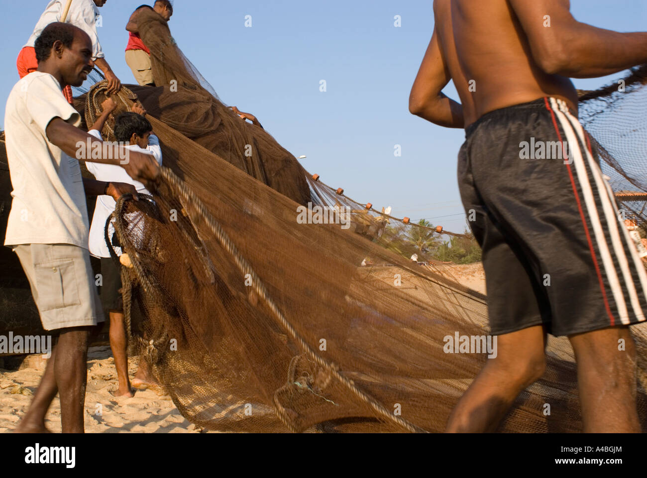 Stock image of Goa fishermen loading fishing nets onto fishing boat on ...