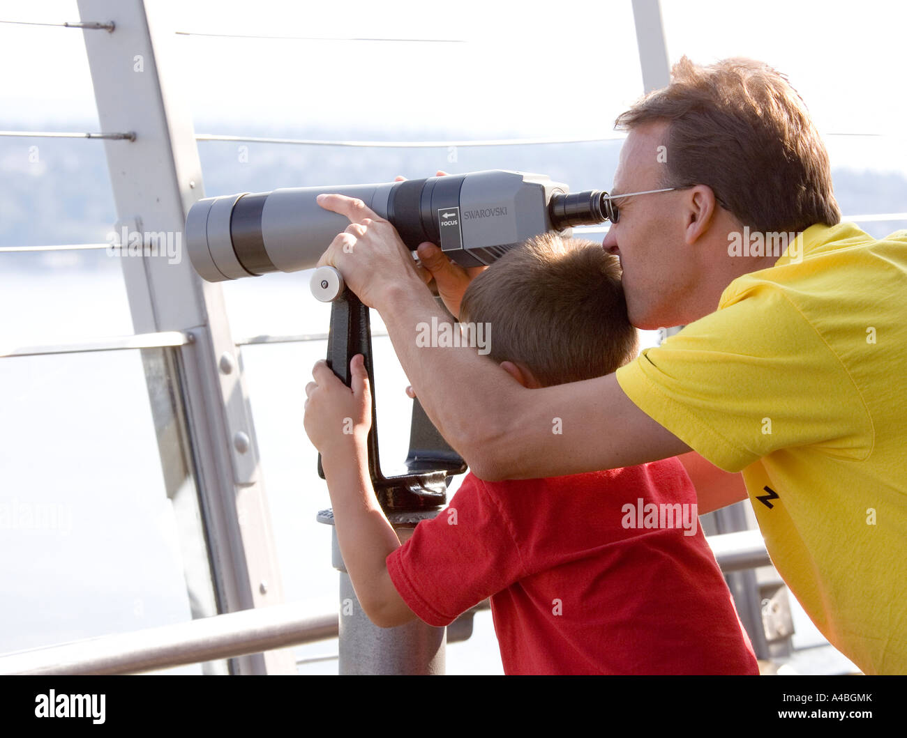 Man and boy using a telescope on top of the Space Needle Seattle USA ...