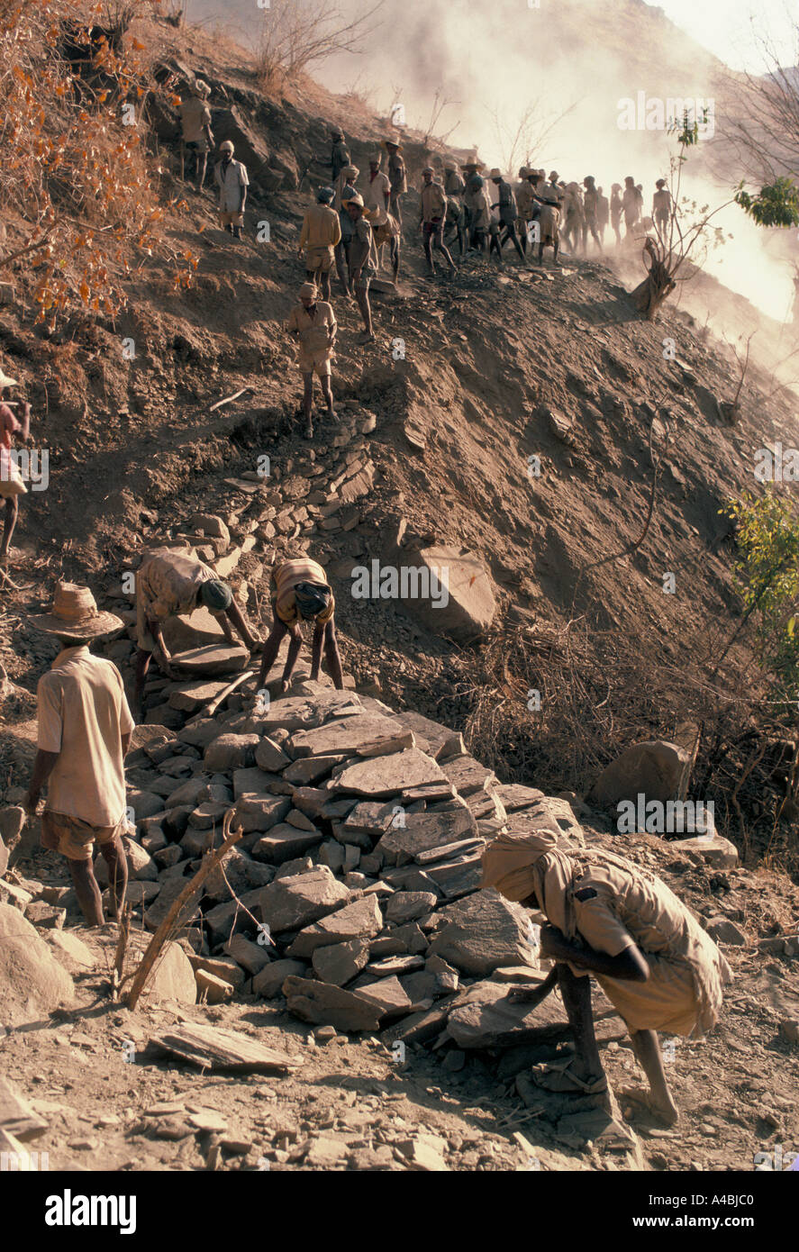 group of men road building with rocks on hillside Stock Photo - Alamy