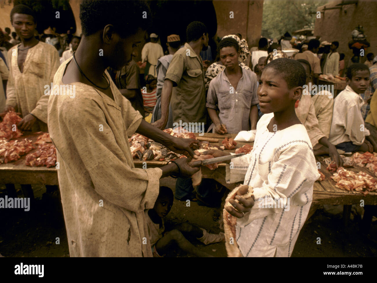 traders and customers with stalls and cuts of meat at meat market in ...