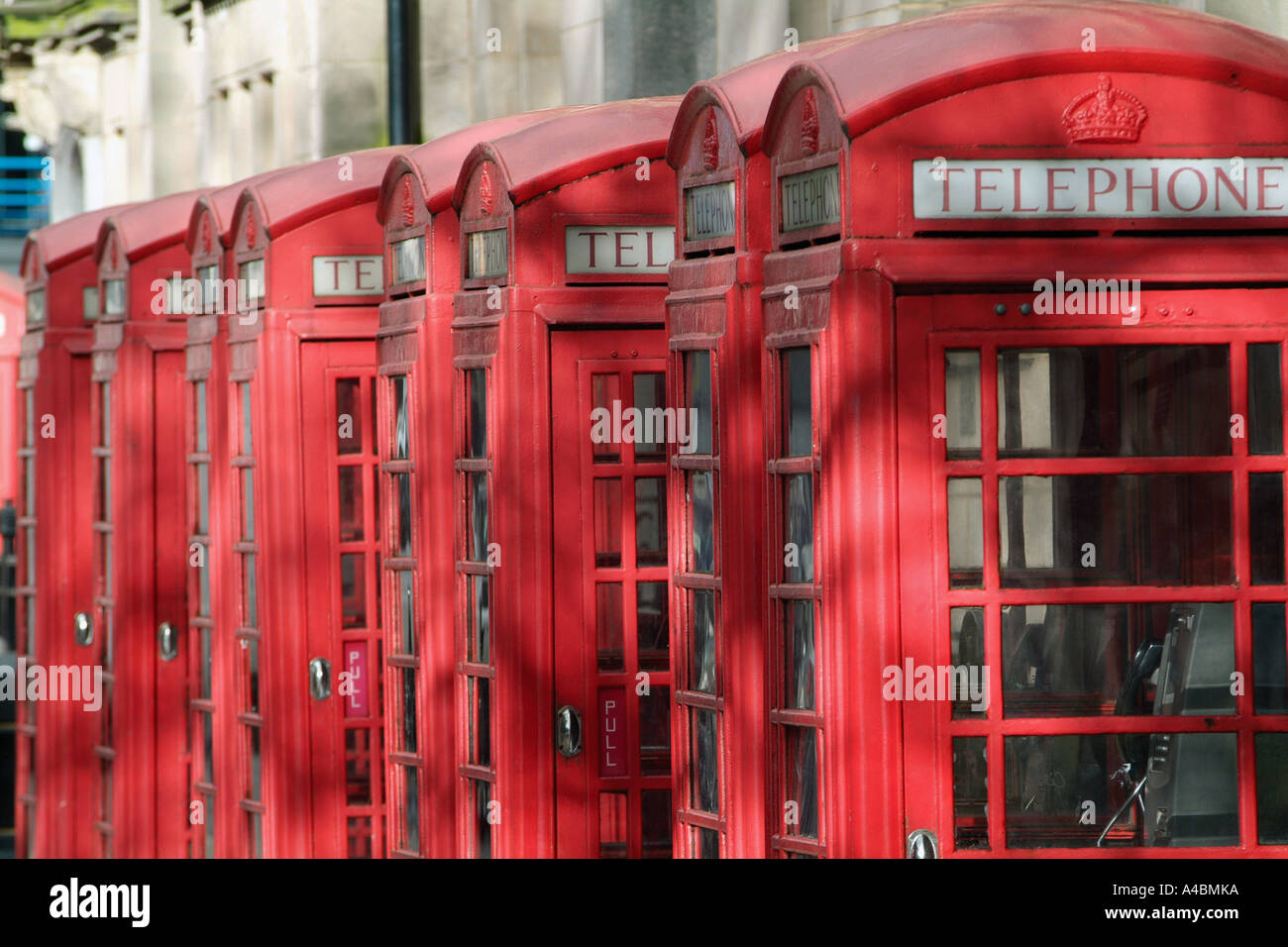 a tight composition of a row of old fashioned English red telephone ...