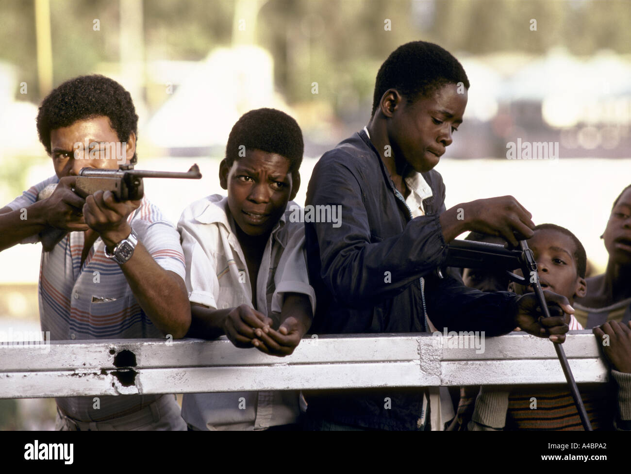 maputo scenes man firing teenaged boy loading air rifle mozambique Stock Photo - Alamy