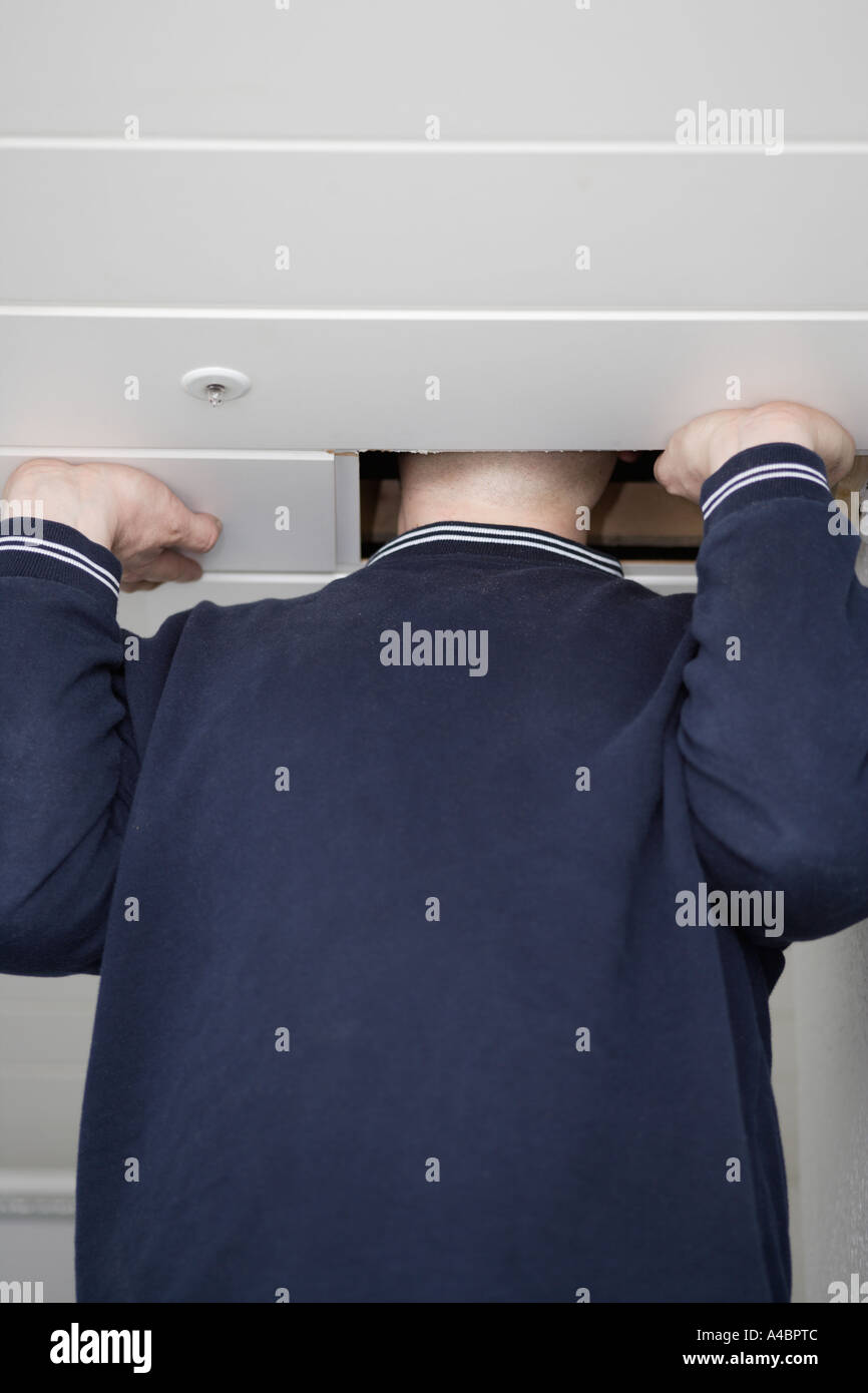Man sticking his head through a hole in the ceiling Stock Photo - Alamy