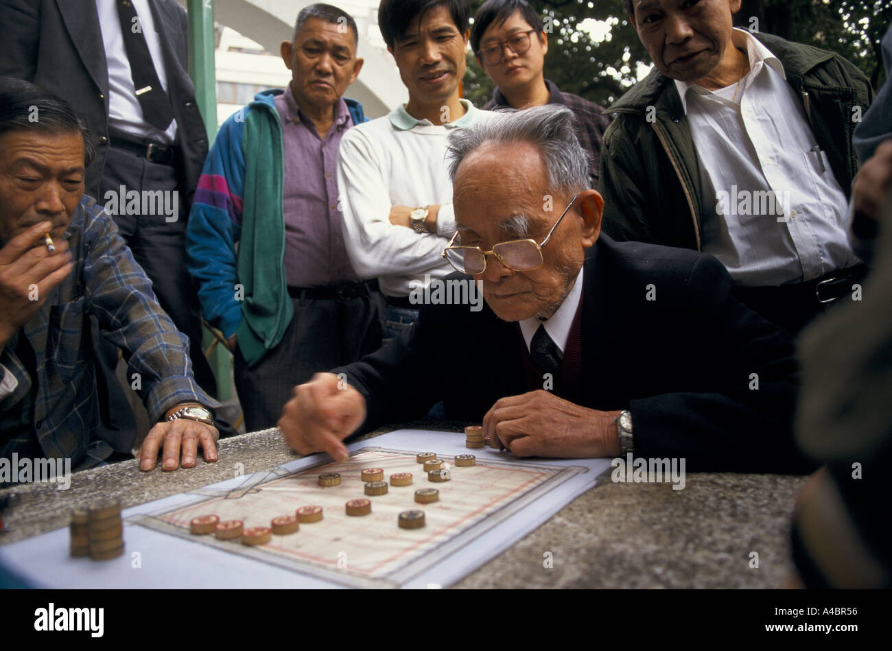 HONG KONG PEOPLE GATHERED AROUND WATCHING OLD MAN PLAYING DRAUGHTS WITH ...