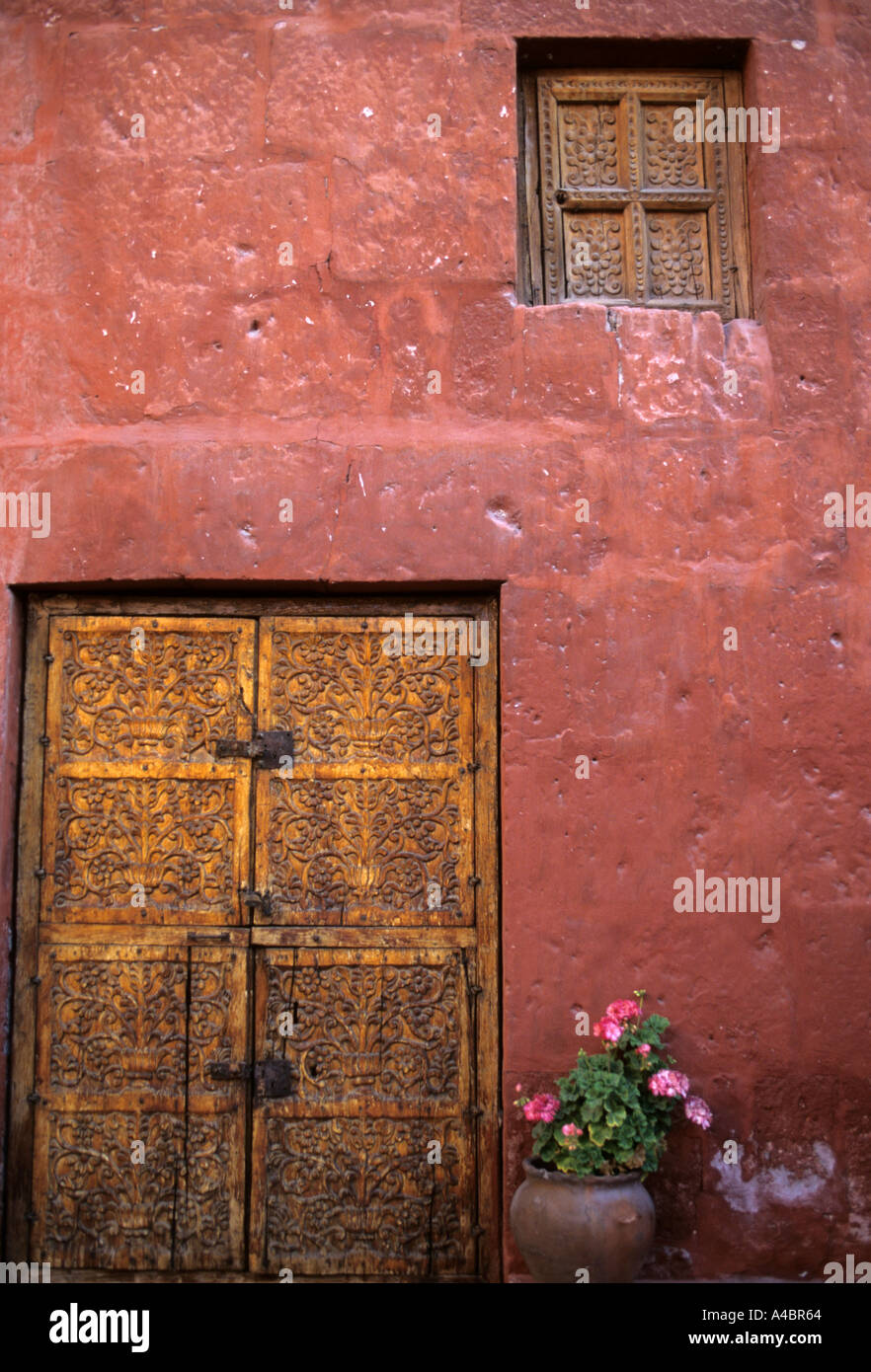 Arequipa, Peru. Carved door and window in a red painted wall with ...