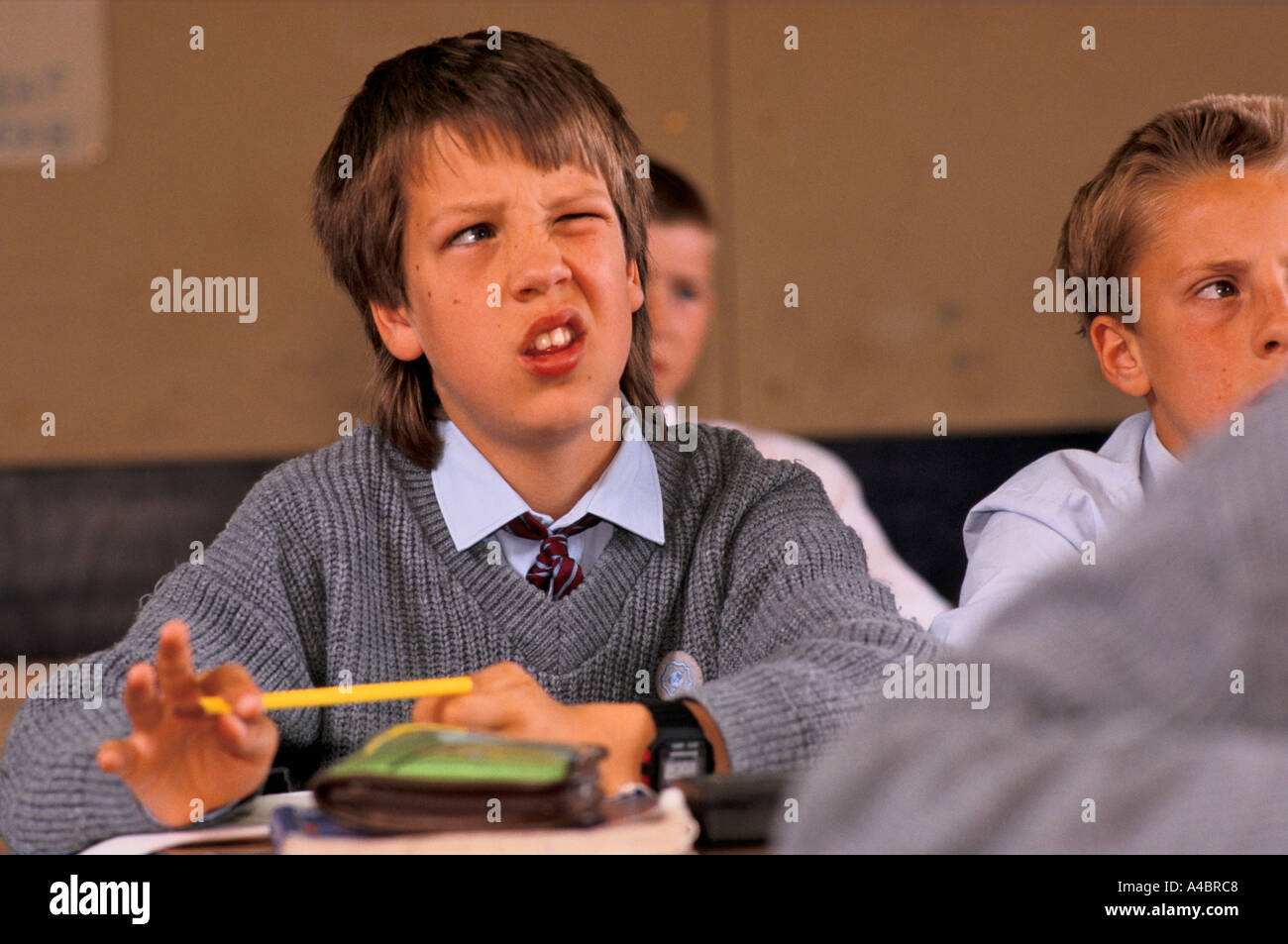 A boy thinks about a question the teacher has just asked during a ...