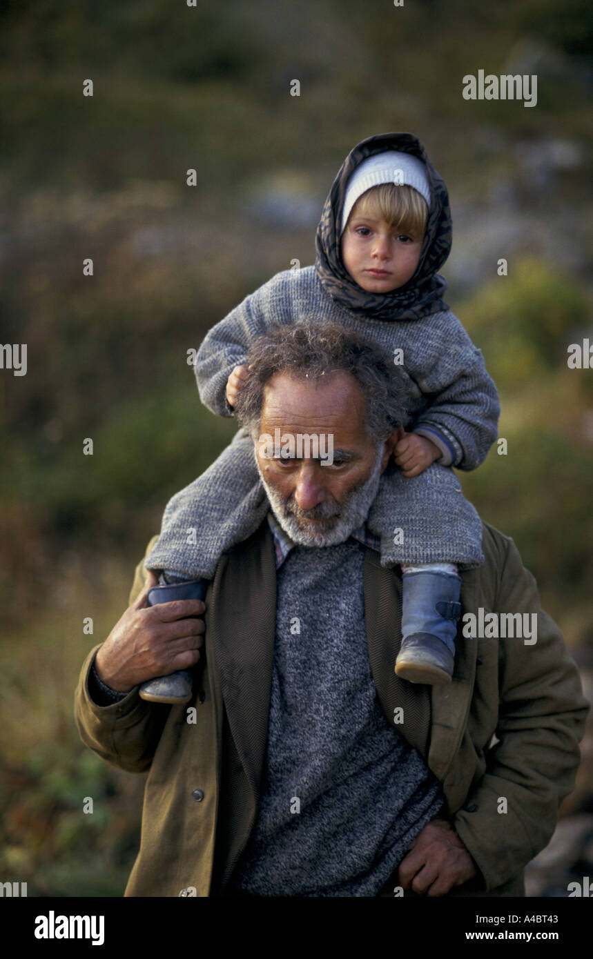 CHUBERI PASS, GEORGIA, OCTOBER 1993: A father carries his daughter on ...