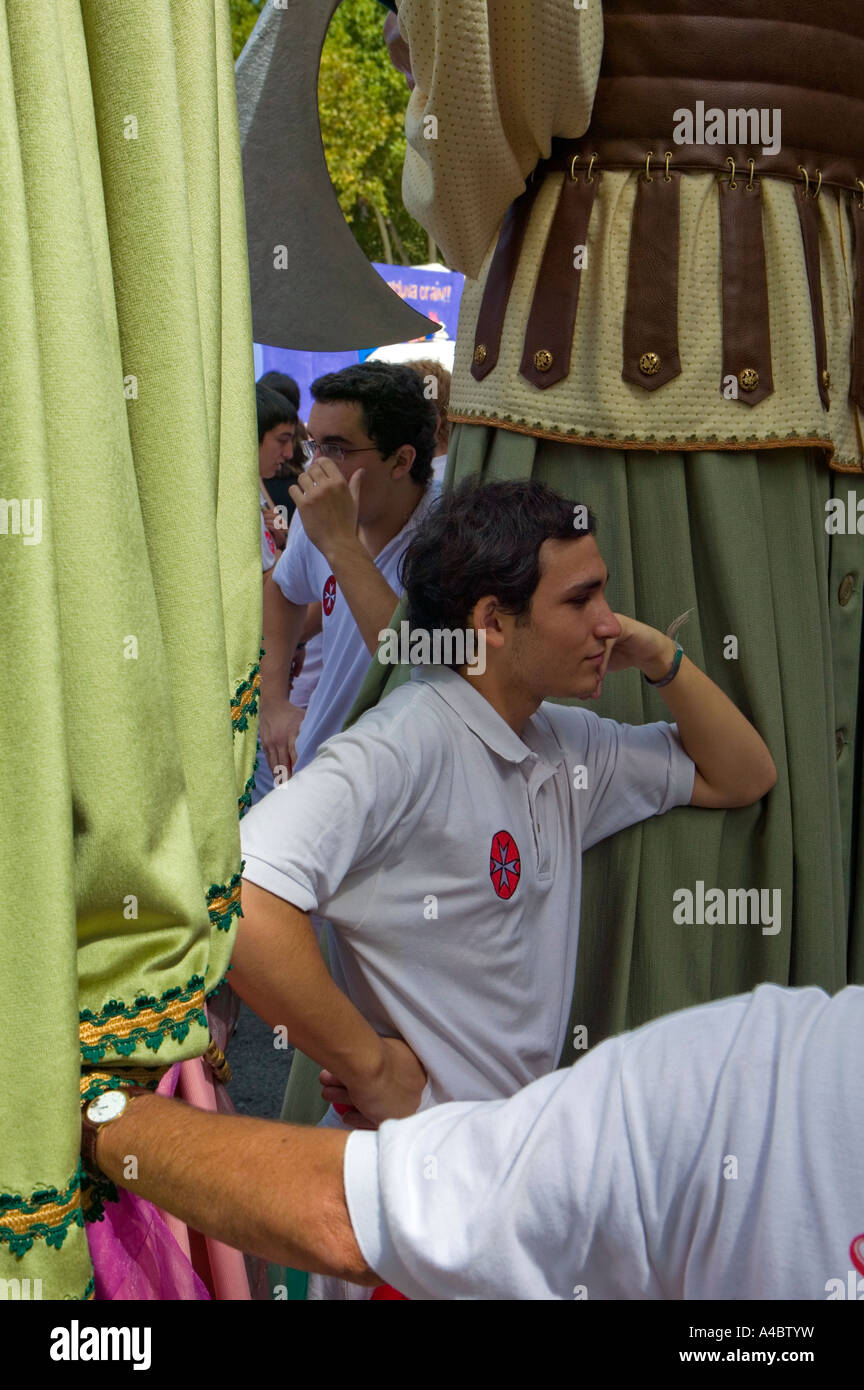 Basque men leaning against gigantes (giants) during break in parade ...