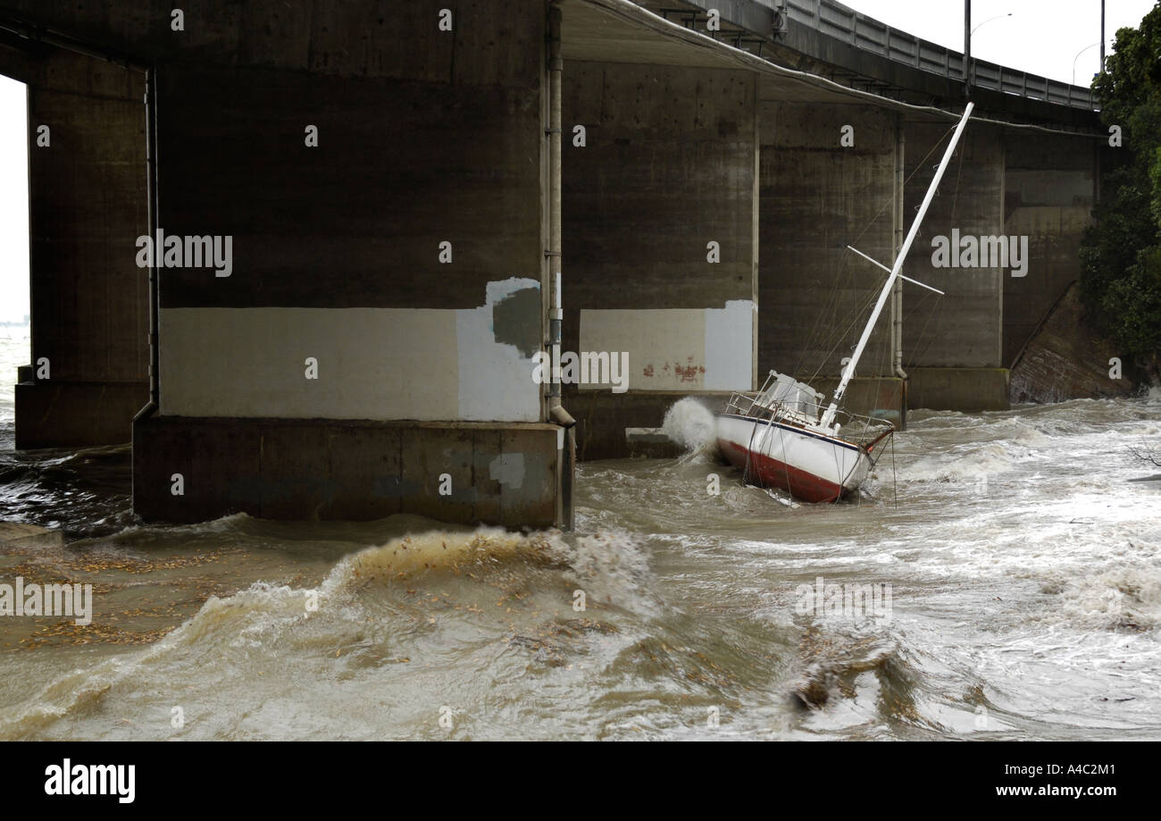 Beached and damaged sailing yacht under bridge approach during stormy ...