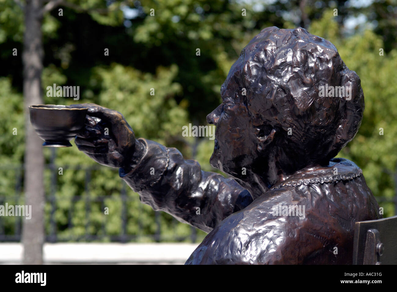 Statue of old lady raising a cup of tea Stock Photo - Alamy
