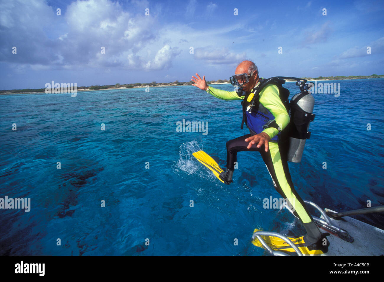 SCUBA DIVER DOING GIANT STRIDE ENTRY INTO WATER BONAIRE NETHERLANDS ...