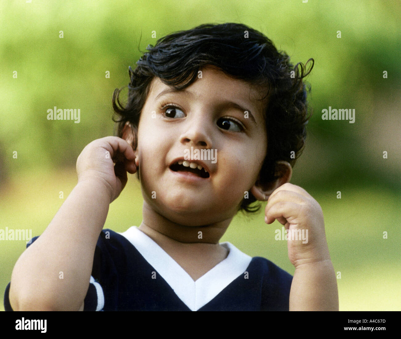 Child pulling his ears Stock Photo - Alamy