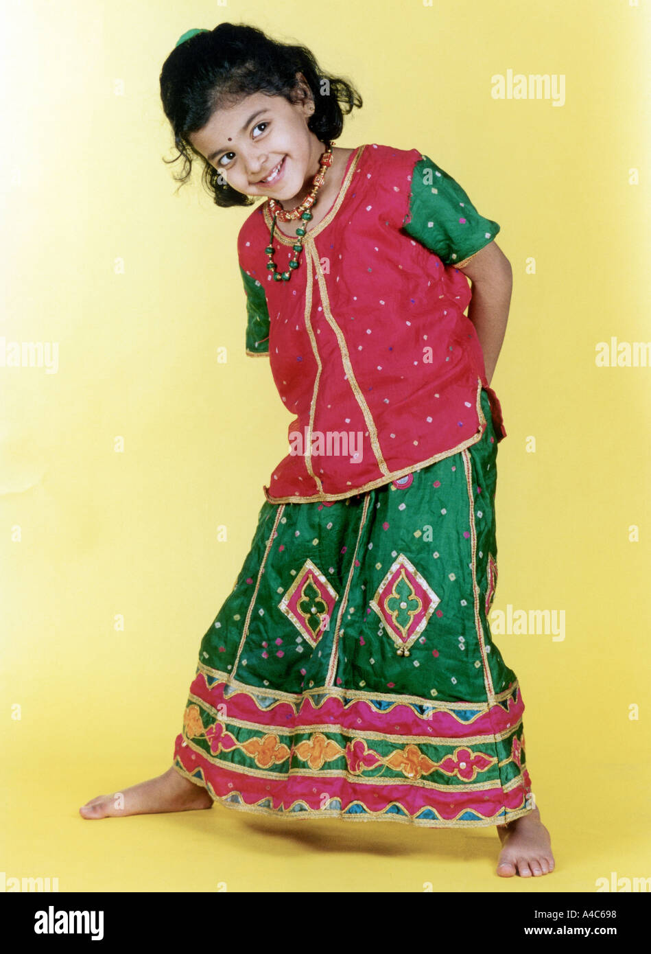 A little girl wearing an embroidered 'ghagra choli', a traditional ...