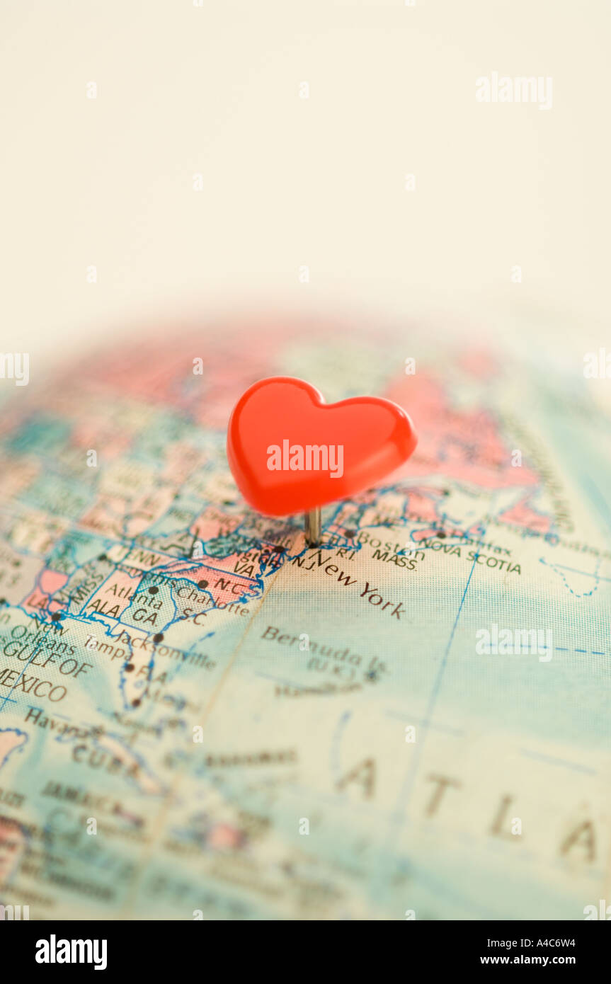 Heart shaped push pin indicating New York city on a globe with selected ...