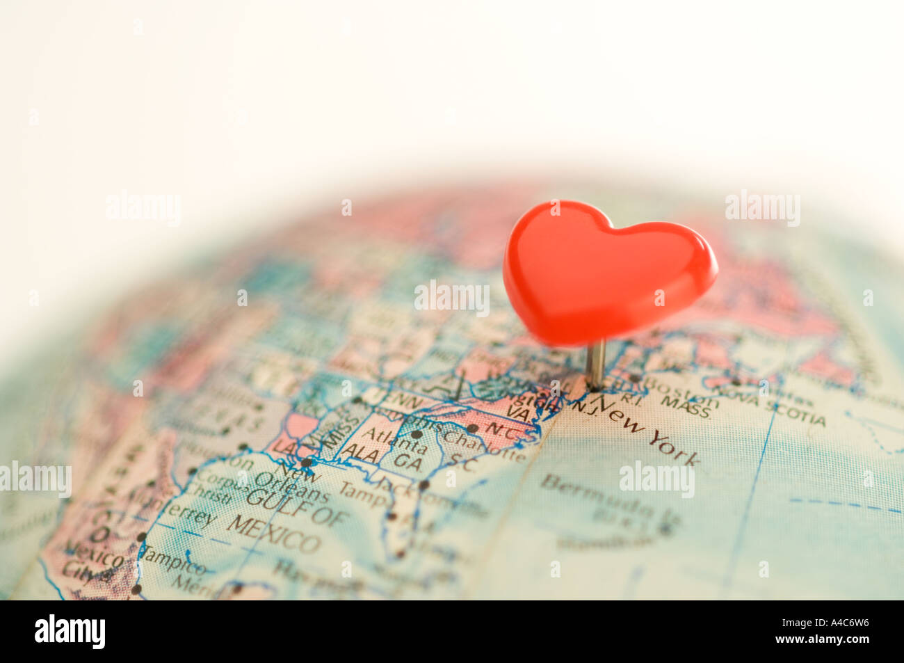 Heart shaped push pin indicating New York city on a globe with selected ...