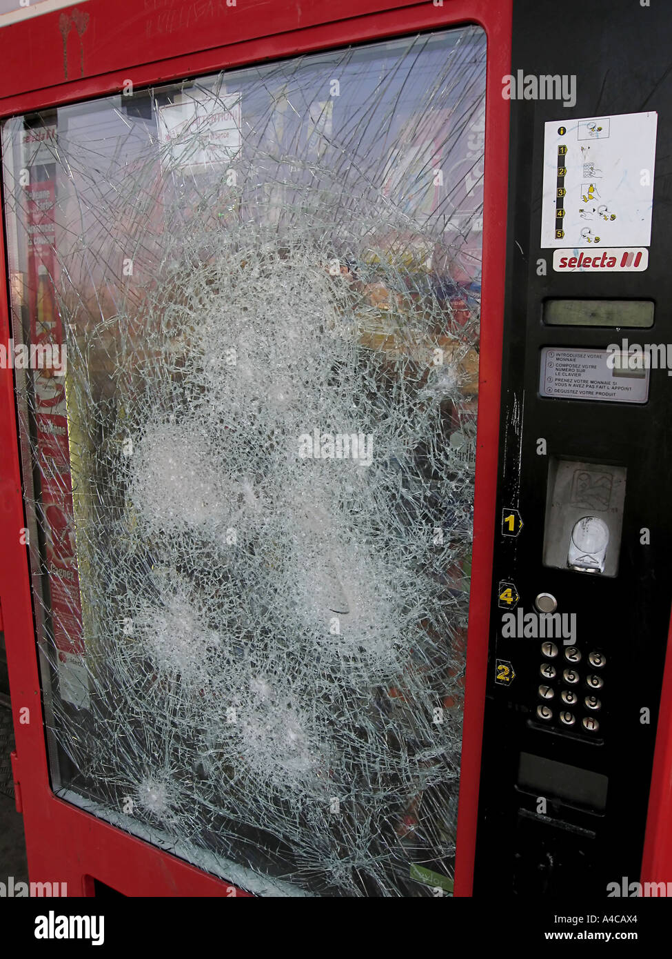 Drink machine with a smashed window in a train station Stock Photo - Alamy