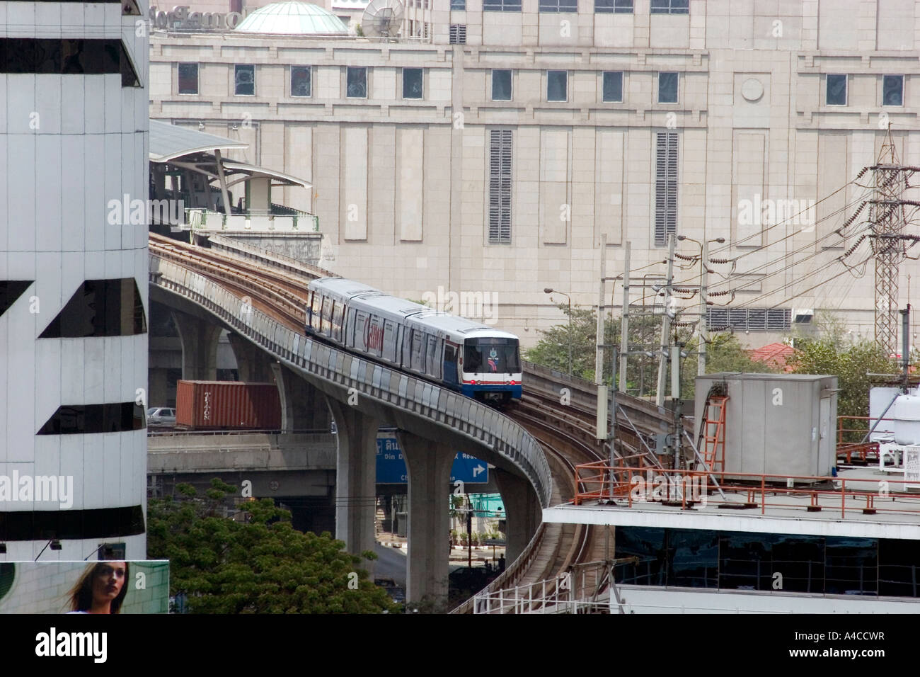 Skytrain BTS train leaving Sukhumvit station on elevated curved railway ...