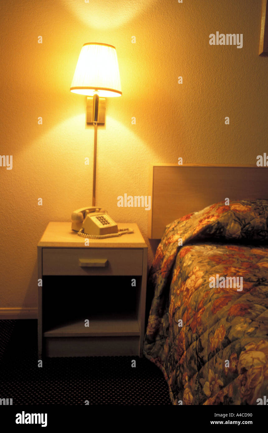 Motel room interior at night showing bed and night stand with telephone ...