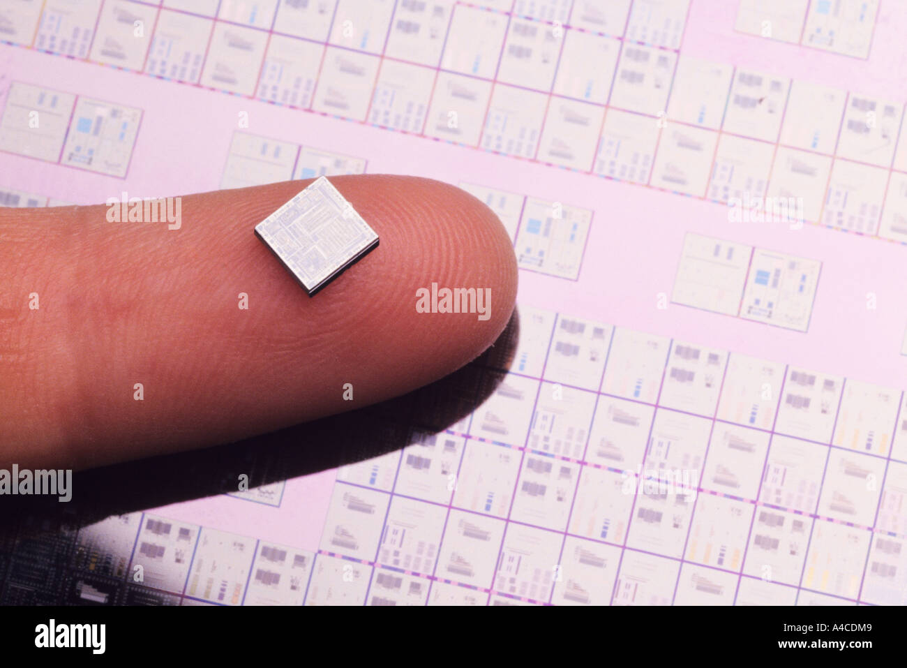 Microchip on finger IC wafer background Stock Photo - Alamy