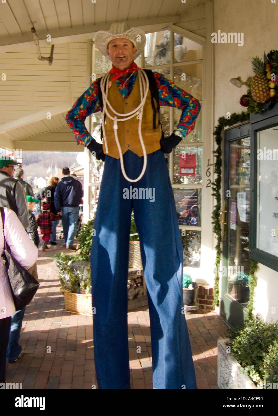 Man dressed as cowboy on stilts Stock Photo - Alamy