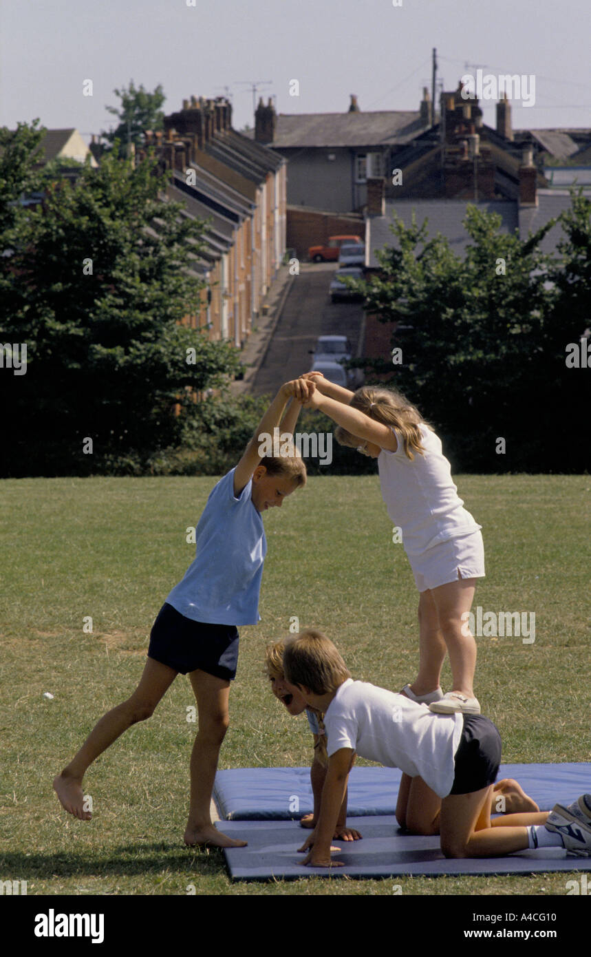 PUPILS DOING EXERCISE ON MAT DURING PHYSICAL EDUCATION LESSON IN ...