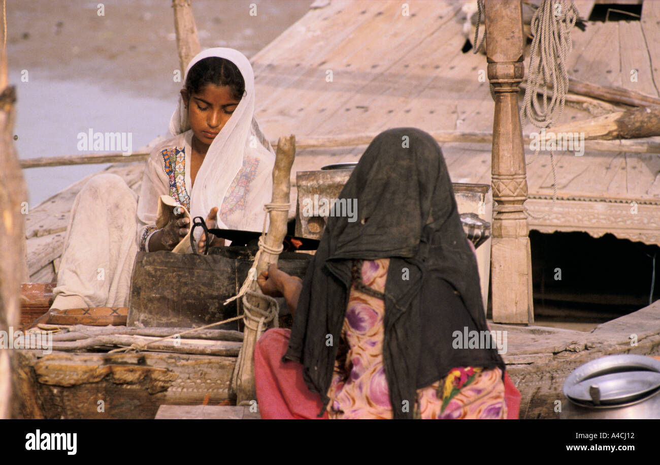 A girl making bread with her mother, Meerbahars on lake Manchar ...