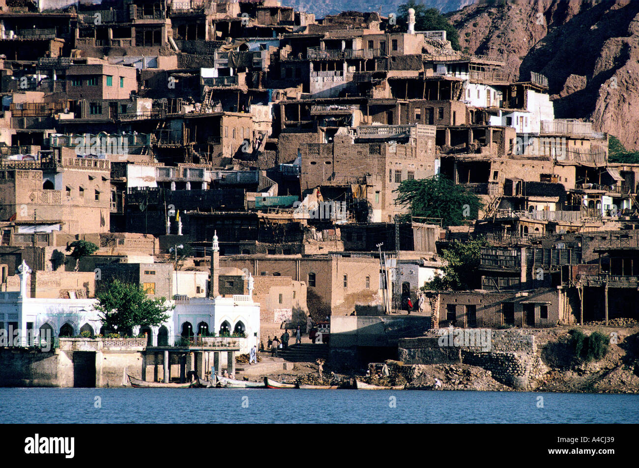Village buildings nestle into the steep walls of the Indus river valley ...